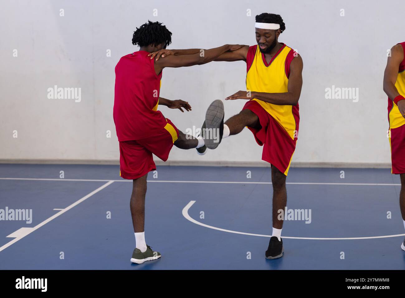 Playing basketball, two athletes practicing defensive moves on indoor ...