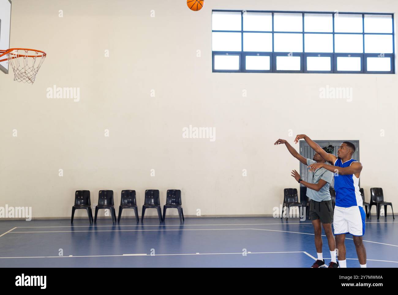 Playing basketball, african american men shooting hoops in court ...