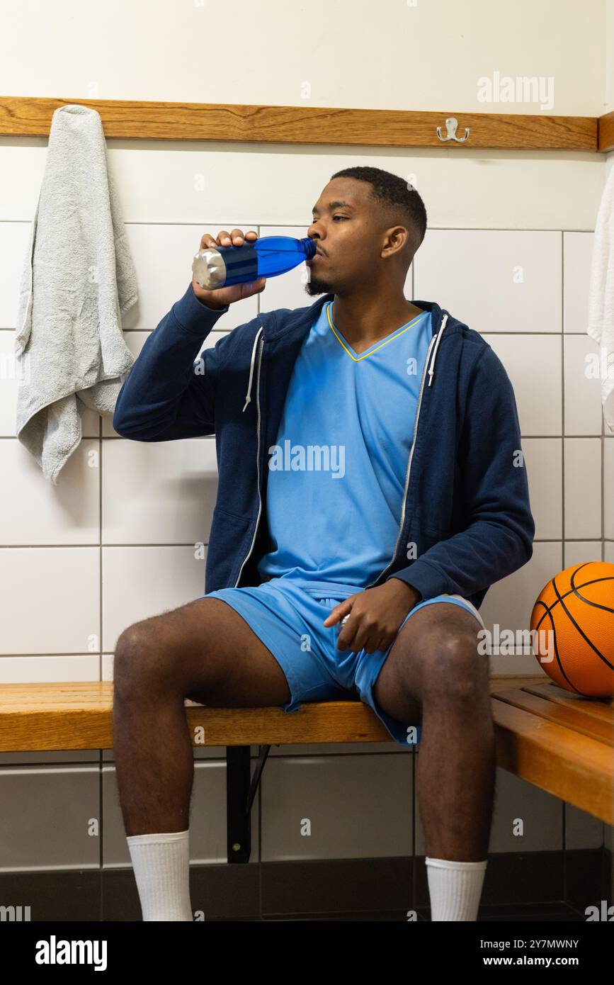 Drinking water, African American Basketball player in locker room ...