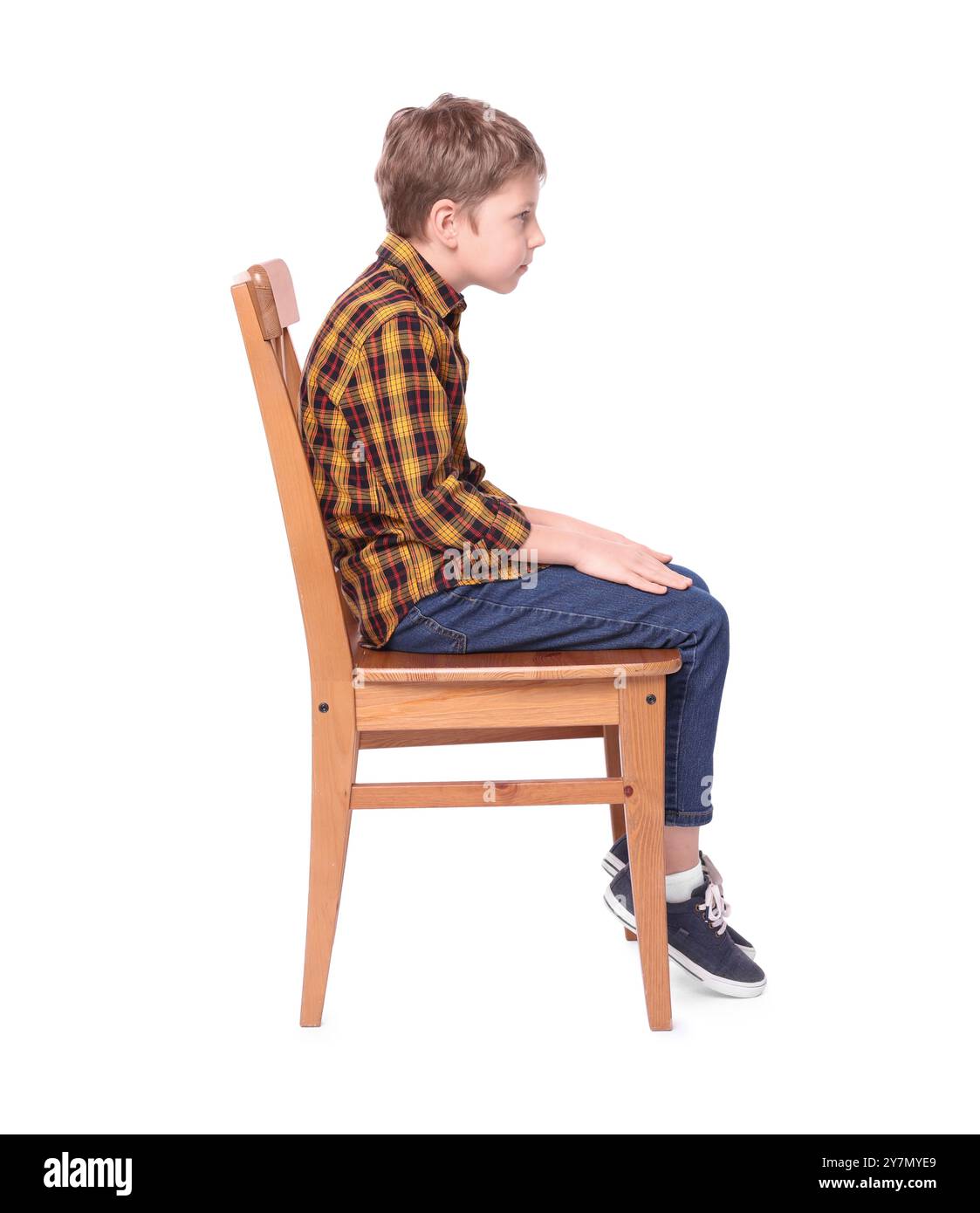 Boy with incorrect posture sitting on chair against white background ...