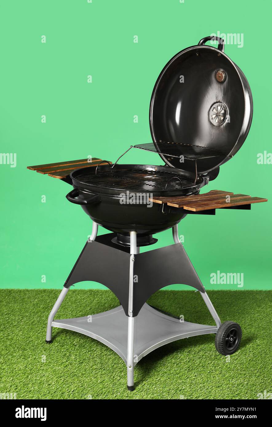 One black barbeque grill on grass against green background Stock Photo ...