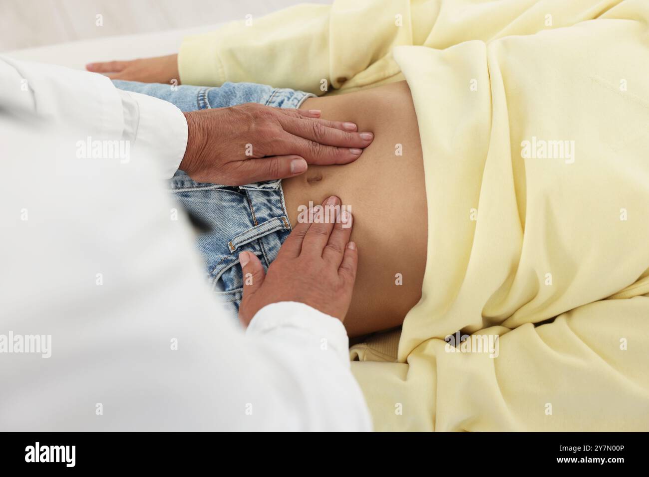 Doctor examining woman with stomach pain in clinic, closeup Stock Photo ...