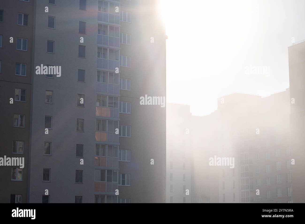 High rise apartment buildings with sunlight shining through the foggy ...
