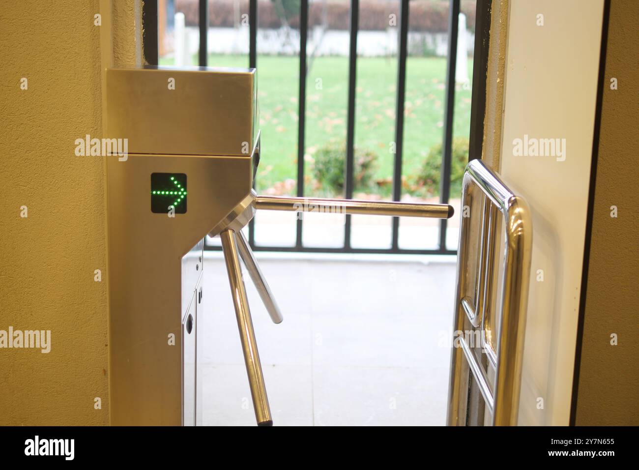 This is a modern turnstile entrance featuring an open door and a ...