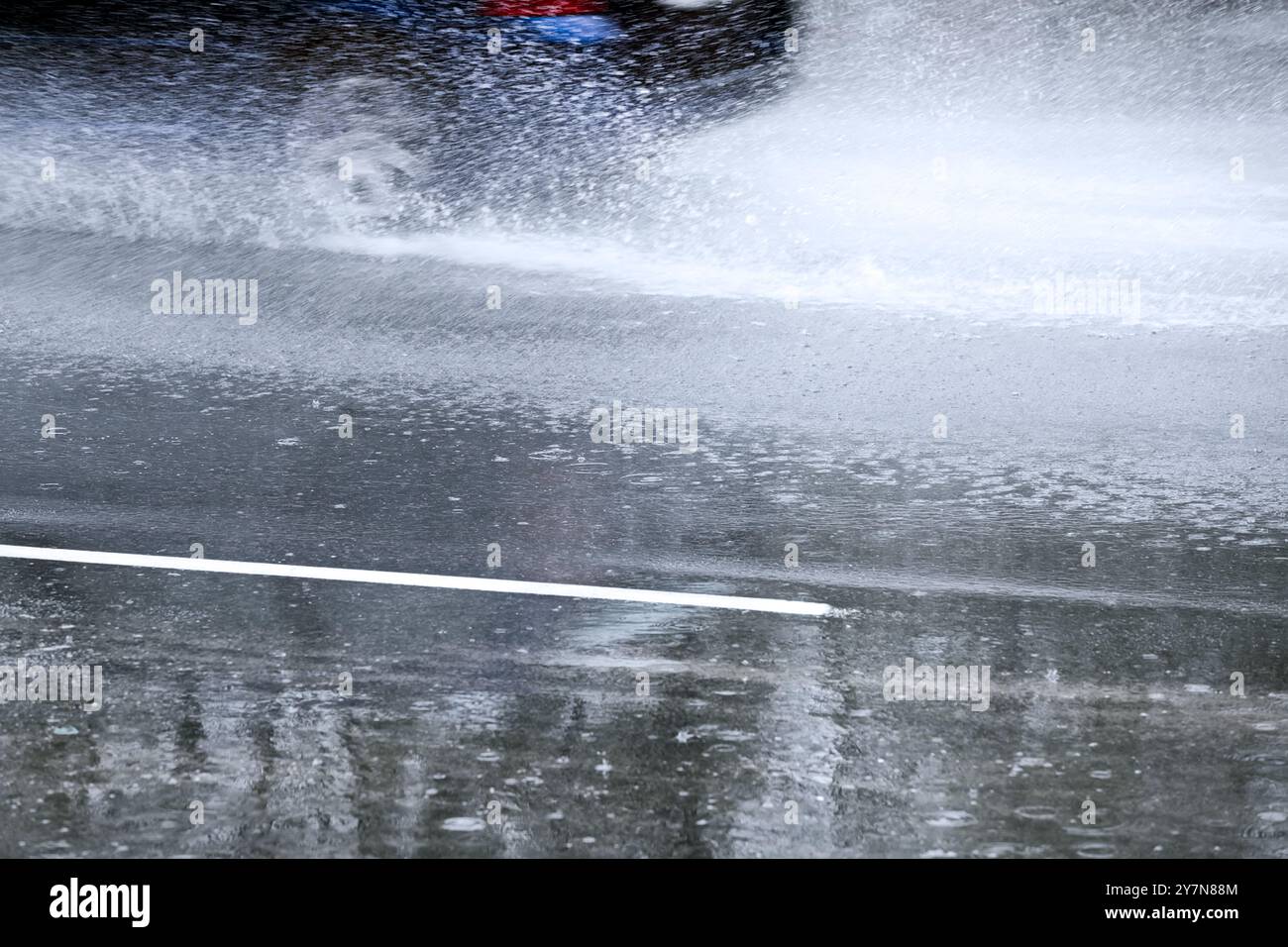 car ride with splashing water on the flooded road during rainy weather ...