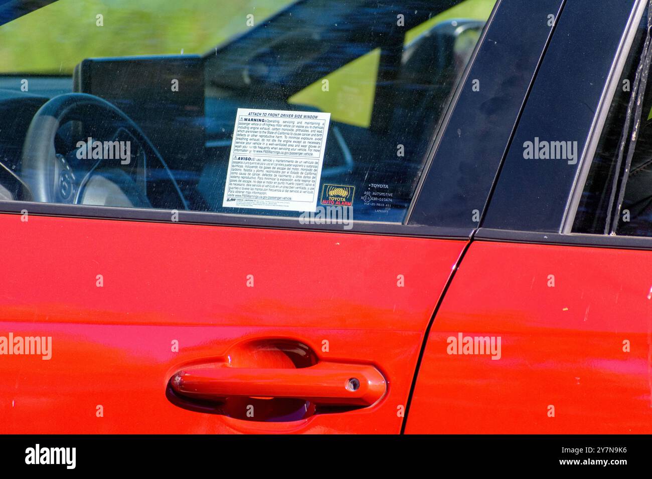 Proposition 65 warning label is attached to the driver side window of a ...