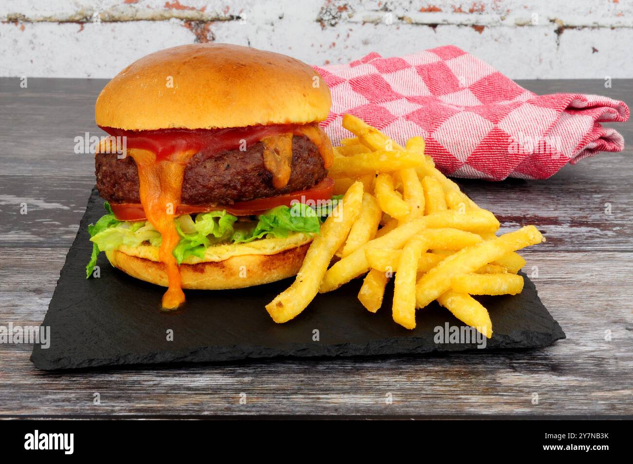 Quarter pound cheese burger and French fries in a brioche bread roll ...