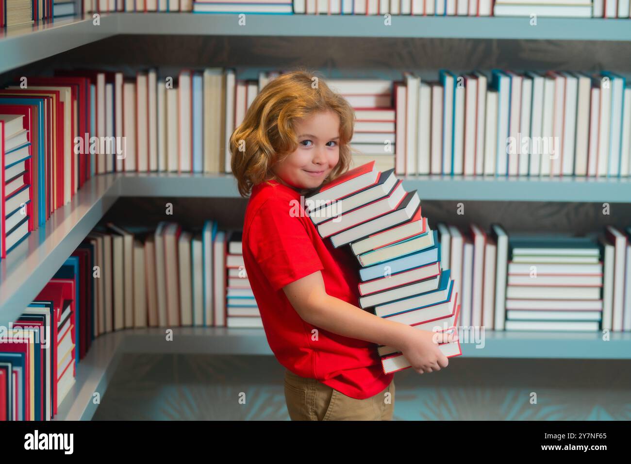 Child boy doing homework on desk in school library. Schoolboy studying ...