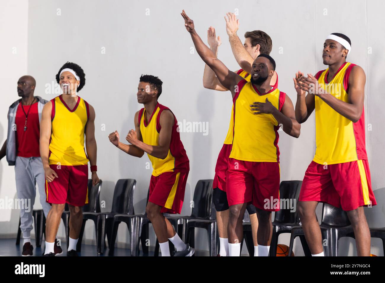 Cheering and celebrating, basketball team in yellow and red uniforms on ...