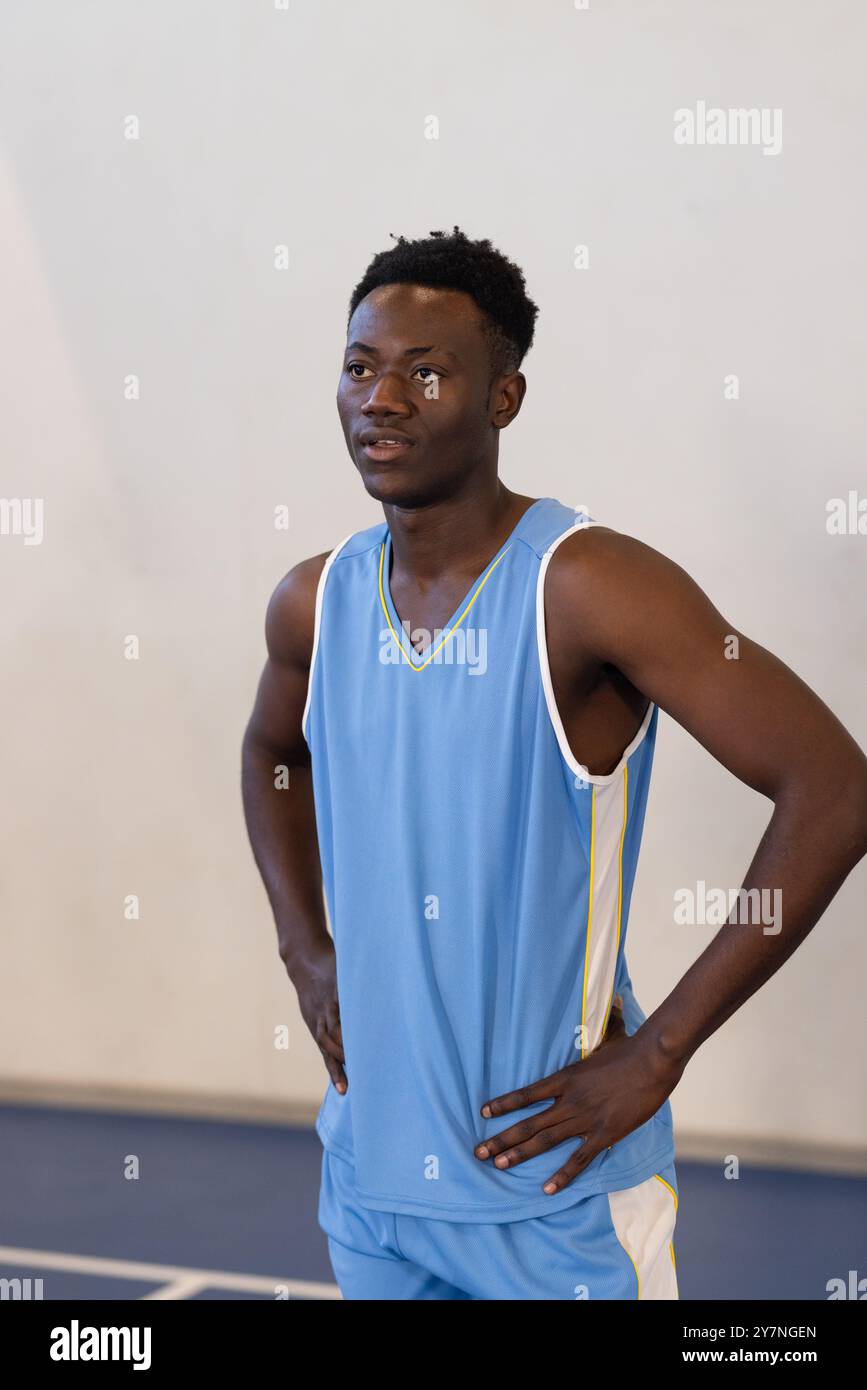 Basketball player in blue jersey standing on court, looking determined ...