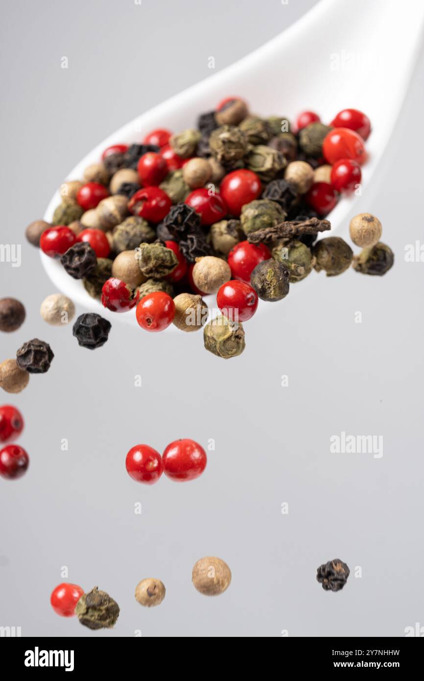 Different types of peppercorns pouring. Red, green, white and black ...