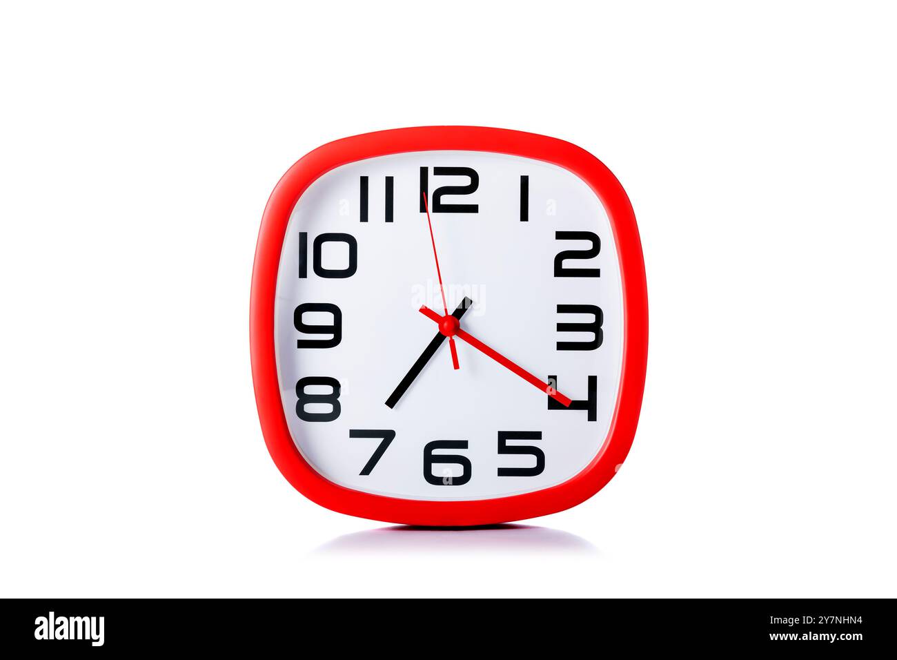 Red wall-mounted analog clock with clear, bold hands, isolated against ...