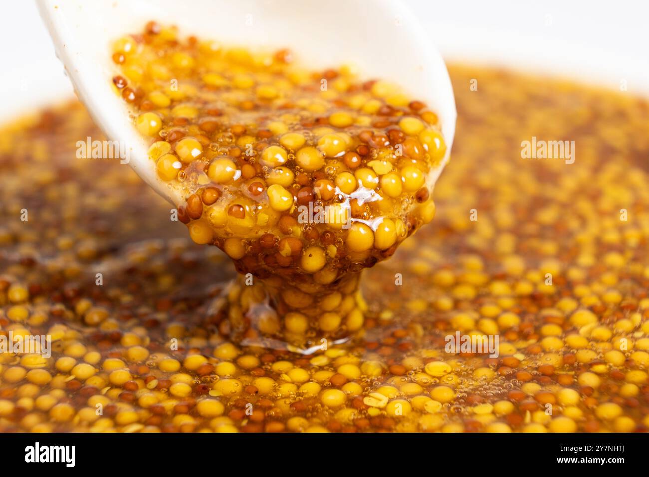 Traditional French Dijon mustard in a spoon on a white background Stock ...