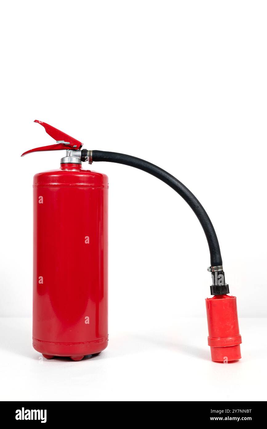 A red cylinder fire extinguisher with a black hose, contrasting on a ...