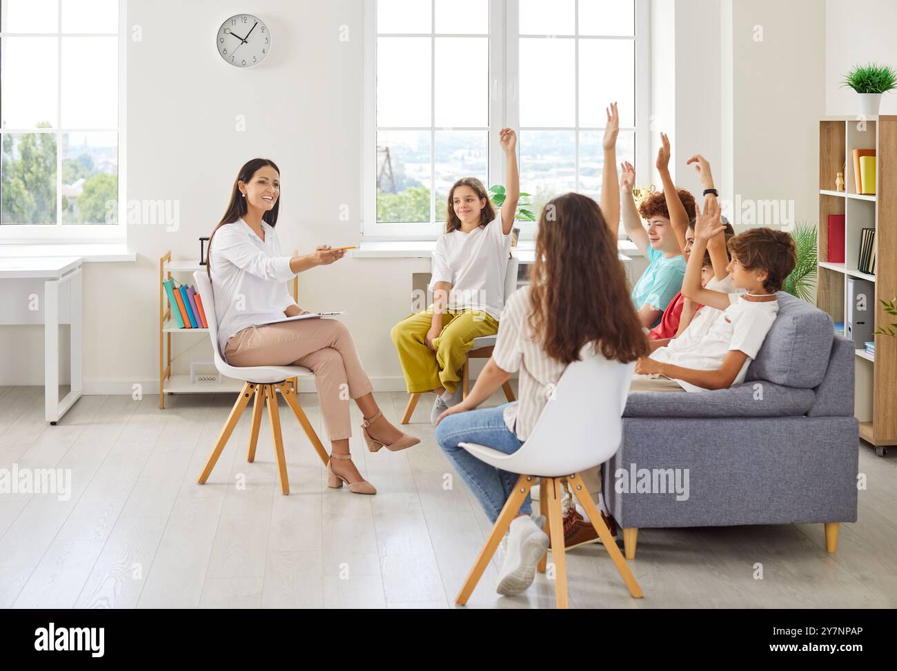 School lesson at home, female teacher giving class asking, happy active students raising hand ...