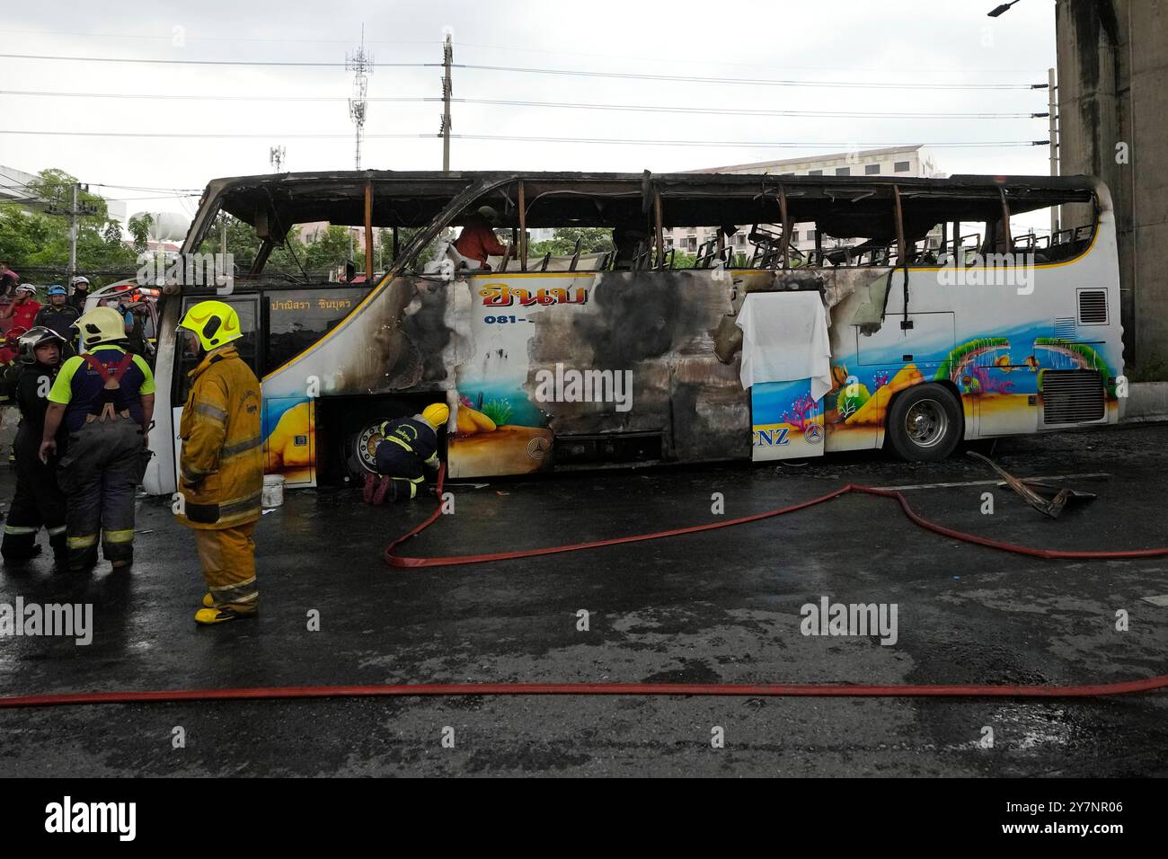 Rescuers work at the site of a bus that caught fire, carrying young ...