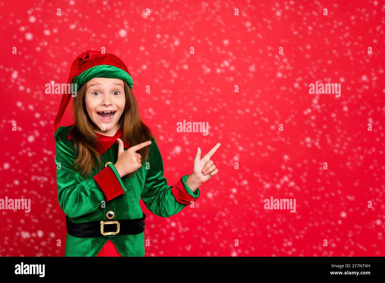 Portrait of impressed funky elf in hat cap showing ads with her index ...