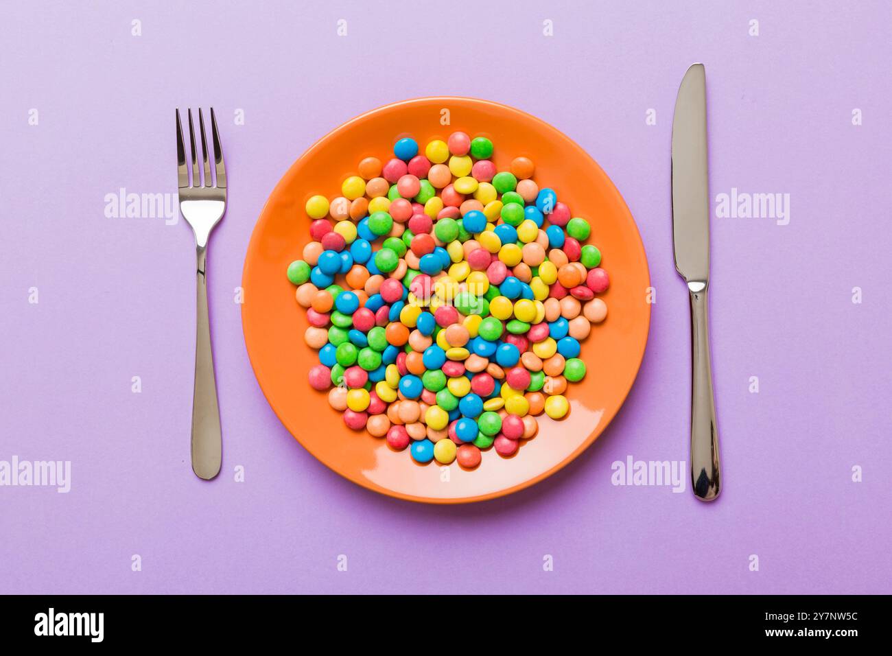 cutlery on table and sweet plate of candy. Health and obesity concept ...