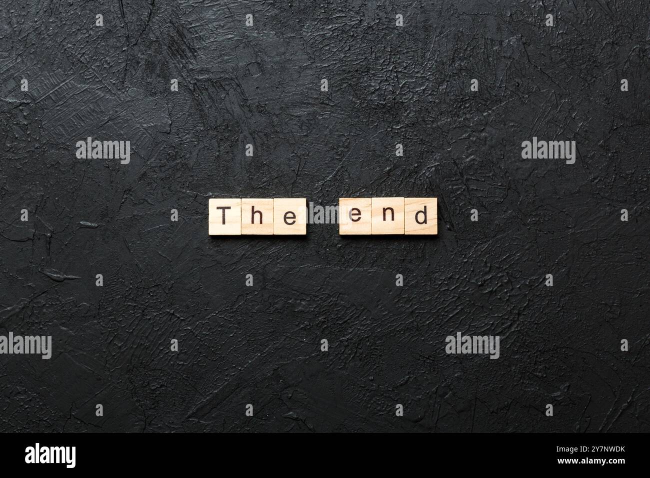 The end word written on wood block. The end text on cement table for ...