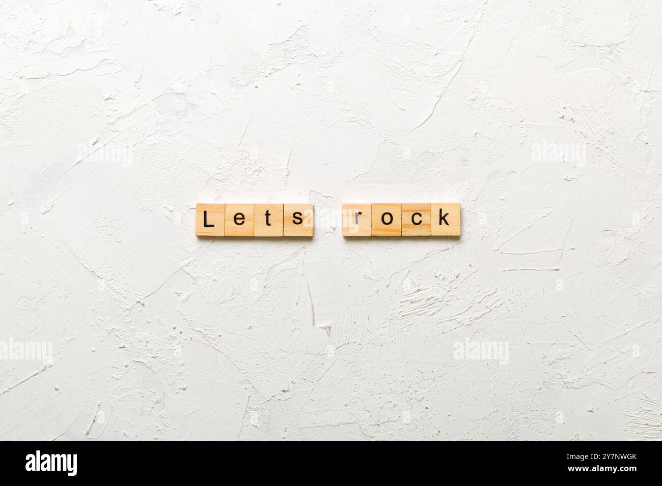 Let's Rock word written on wood block. Lets Rock text on cement table ...