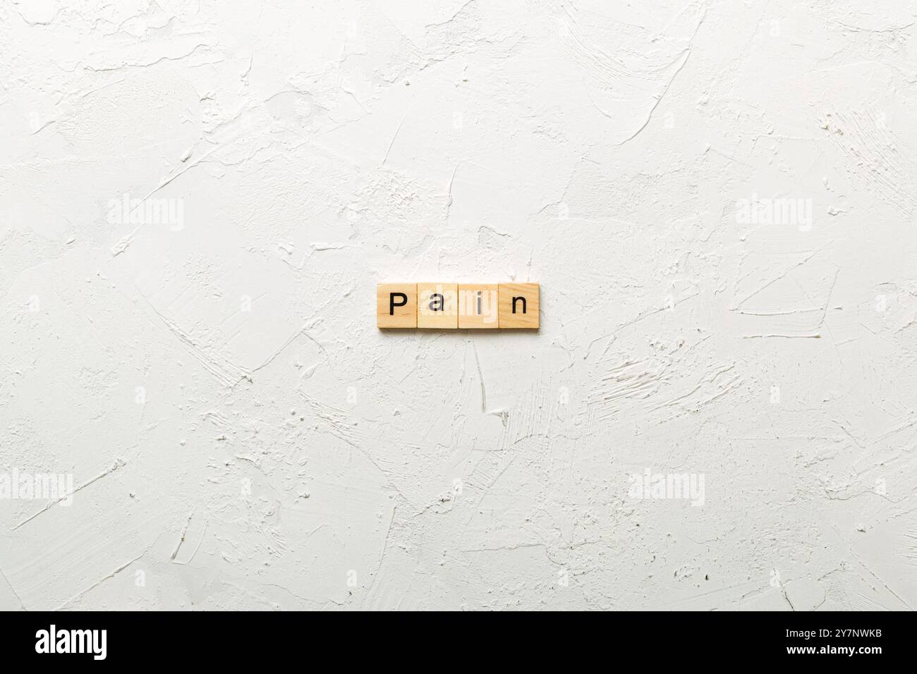 PAIN word written on wood block. PAIN text on cement table for your ...