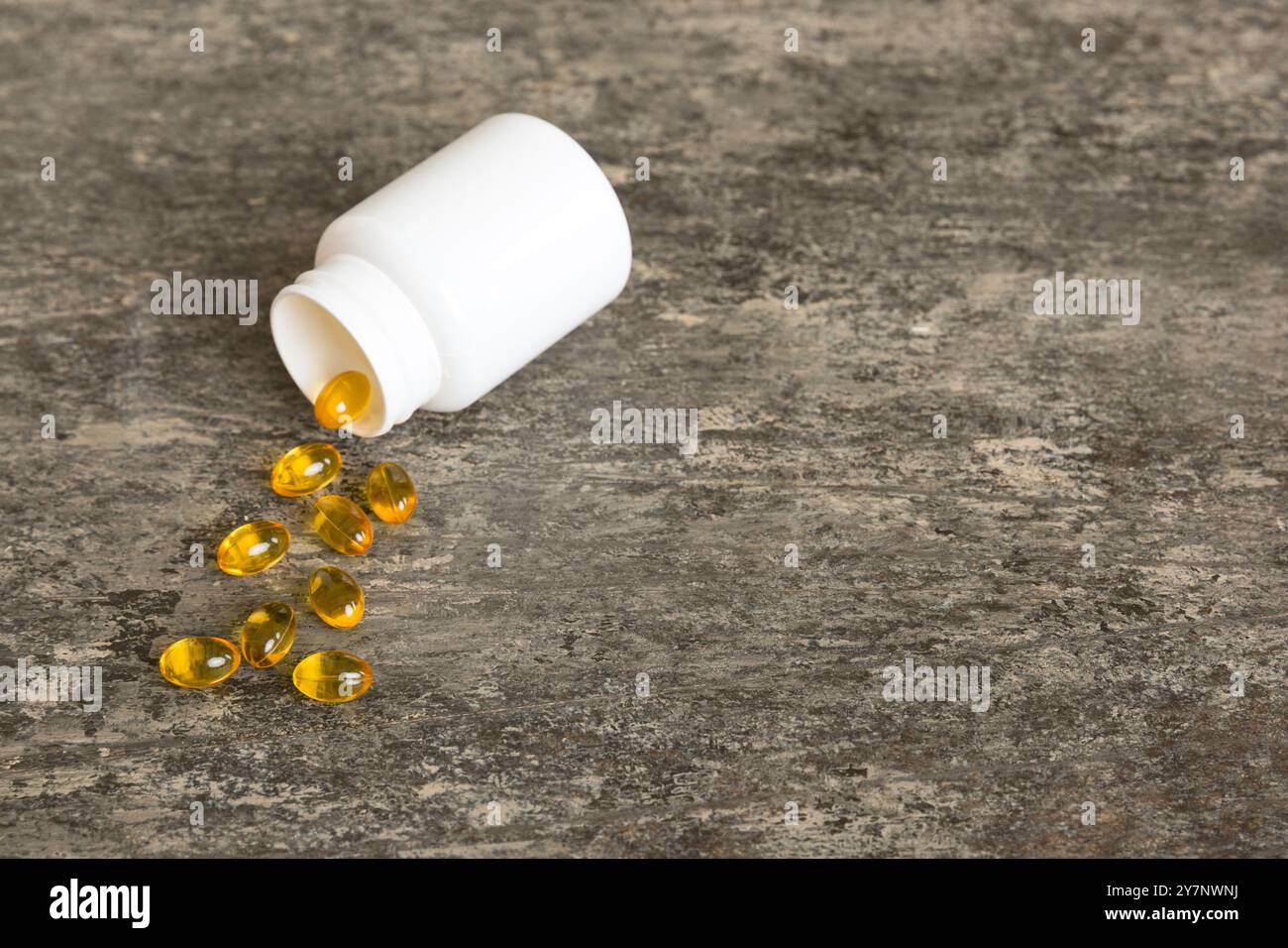 Soft gels pills with Omega-3 oil spilling out of pill bottle close-up ...