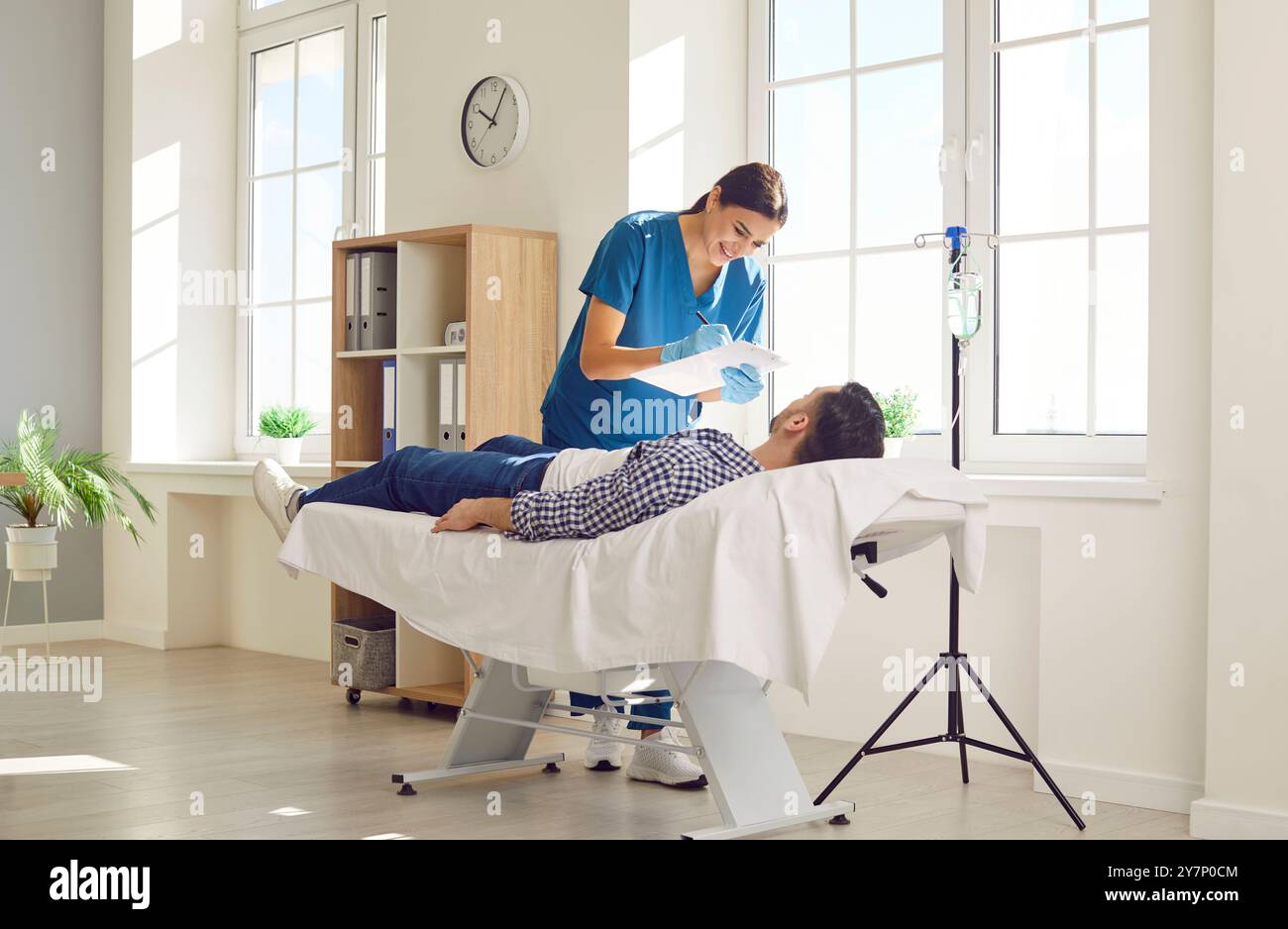 Male patient lying on couch in medical clinic and receiving IV drip ...