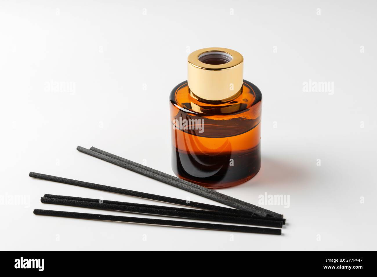 A minimalist display of essential oil and black diffuser sticks on a ...