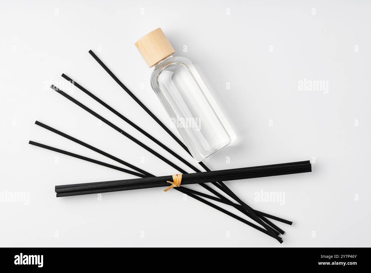 A minimalist display of essential oil and black diffuser sticks on a ...