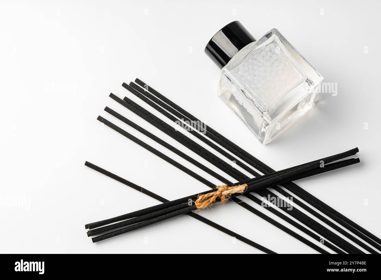 A minimalist display of essential oil and black diffuser sticks on a ...