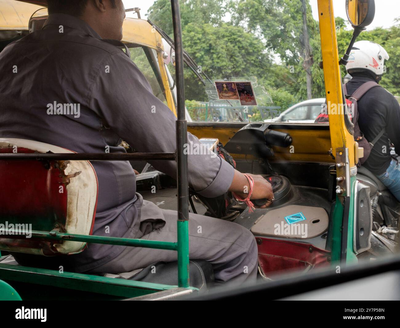 Auto rickshaw driver in central Delhi, navigating by his mobile phone ...