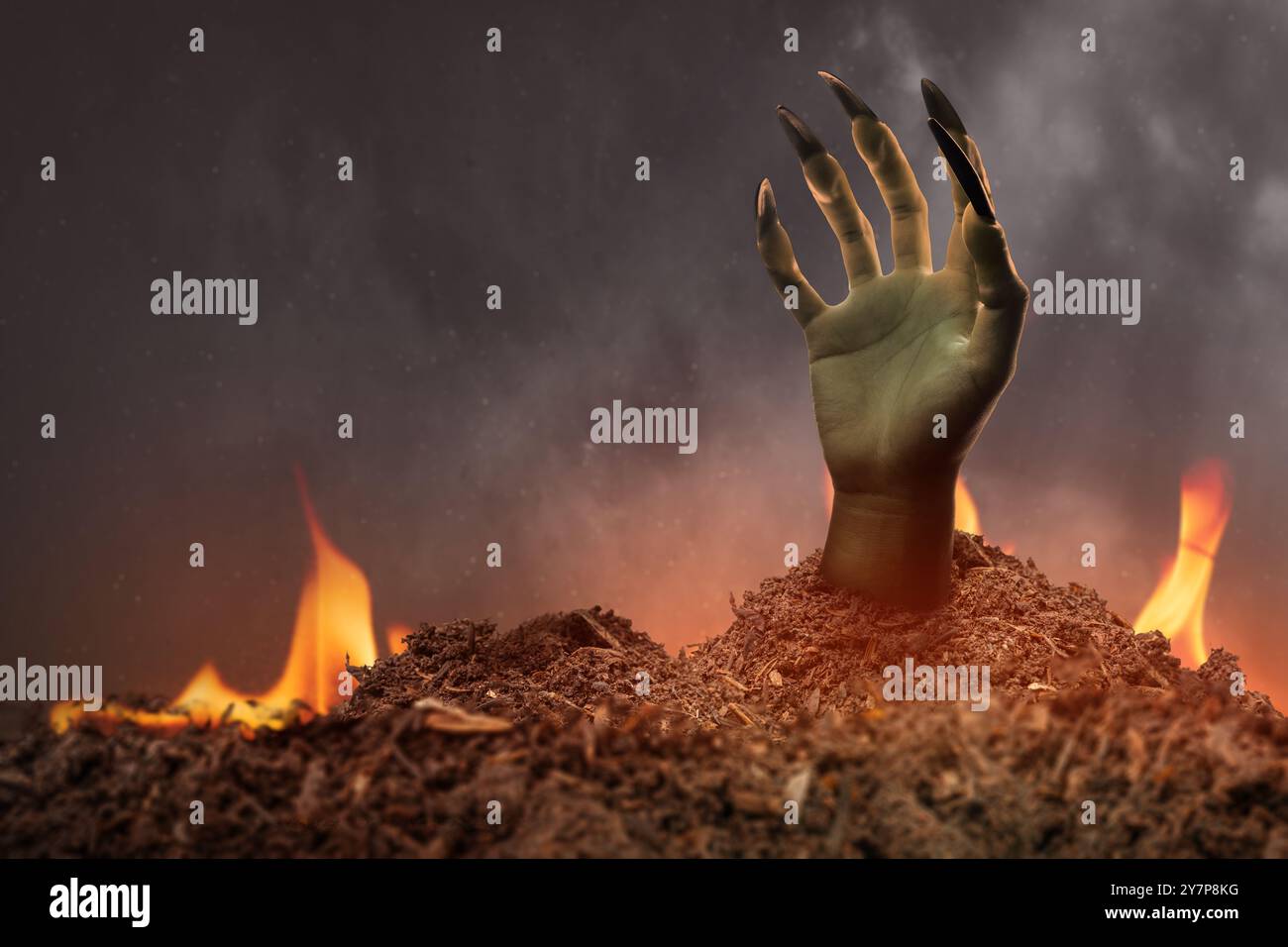 Witch hand with long black nail coming out from grave ground with a ...