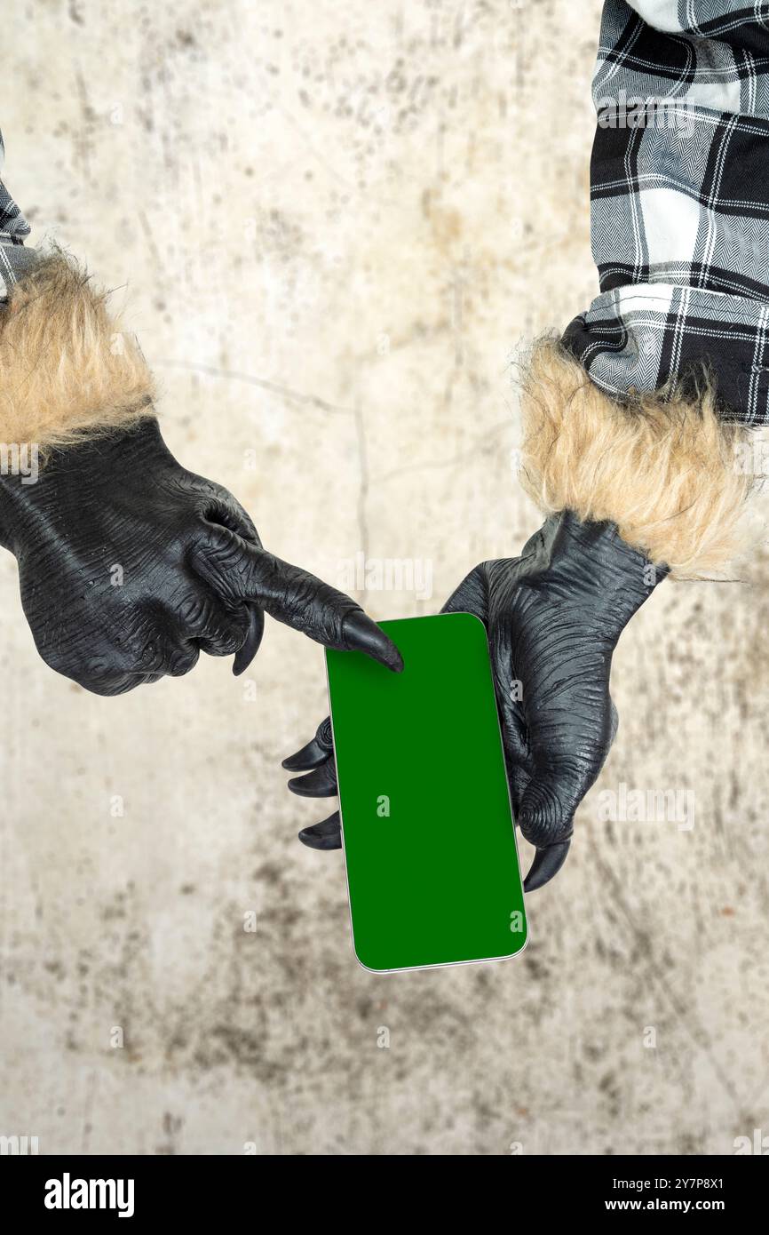 Werewolf hand with fur and black claws using a mobile phone or cell ...