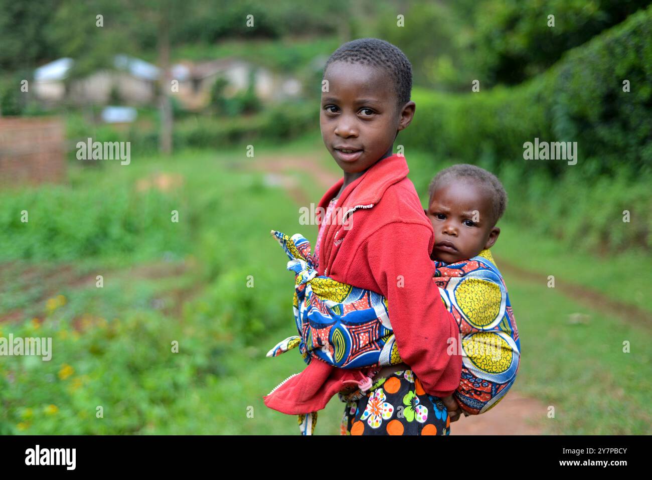 A young girl carrying a baby in Kabale Uganda Stock Photo - Alamy