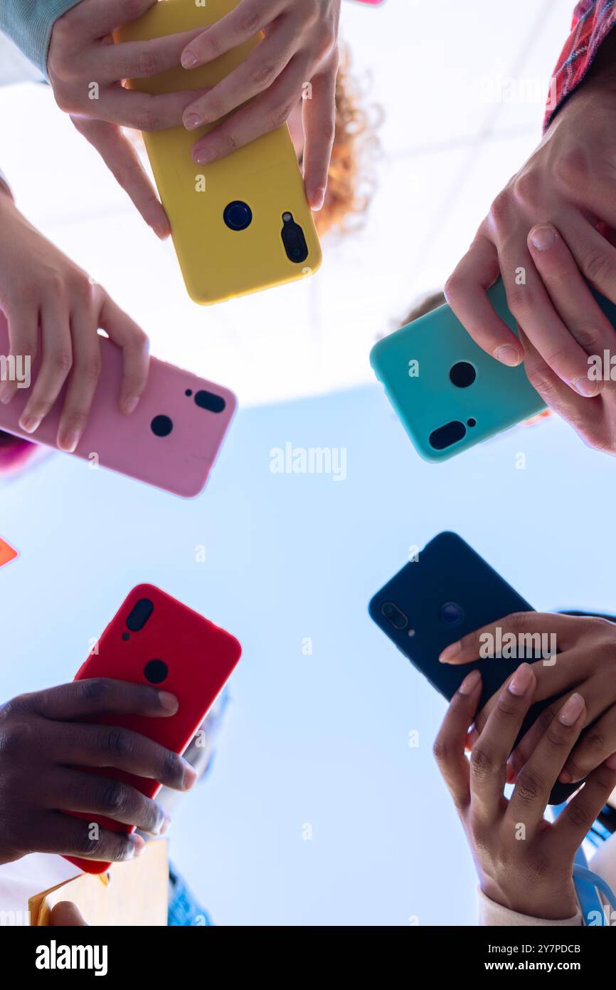 Vertical portrait group of people holding colorful smartphones in a ...