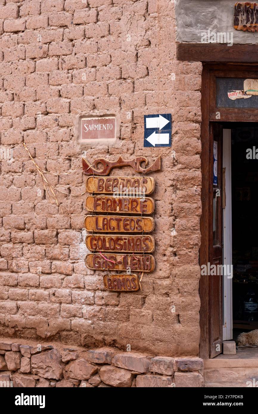 Carved wooden signs on the wall of a store in a traditional adobe brick ...