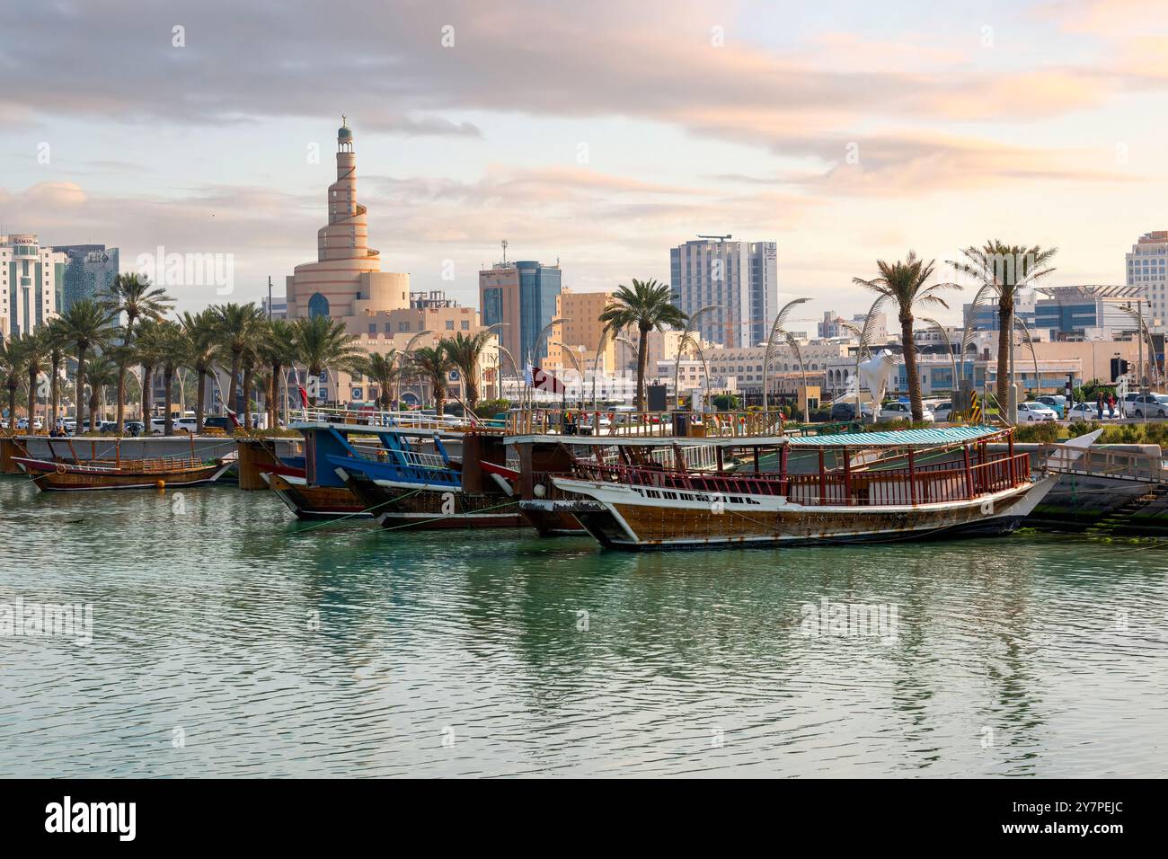 Traditional wooden dhow anchored at Dhow Harbor in Doha Bay with spiral ...
