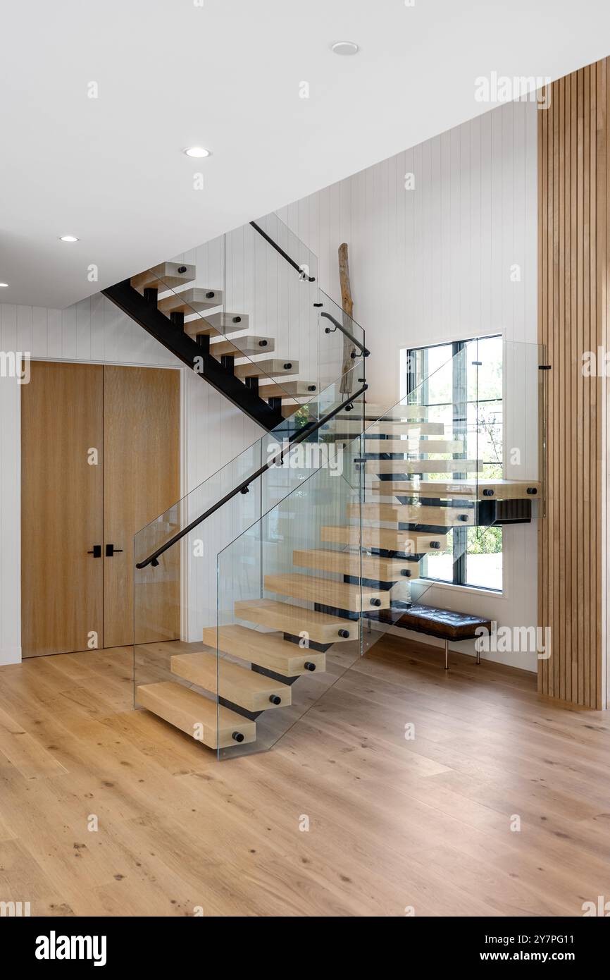 Modern interior with a floating wooden staircase and glass railing ...