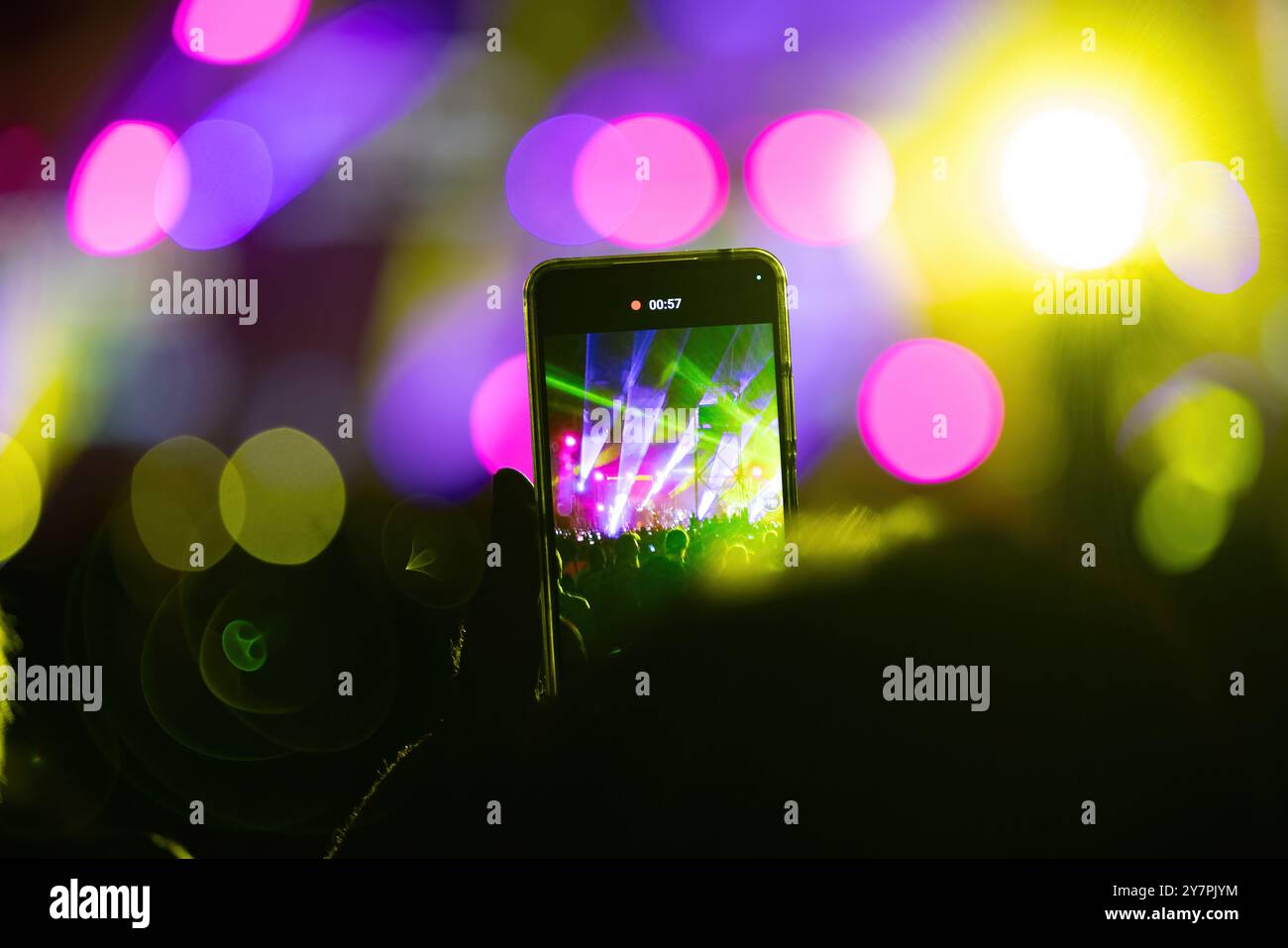 Stage lights as defocus bokeh background at a music concert and hand ...