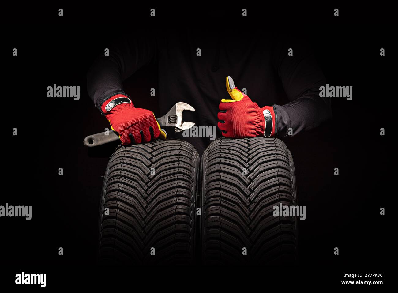 Car tire service and hands of mechanic holding new tyre on black ...
