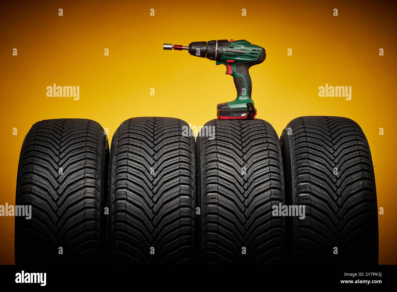 Car tires, winter wheels isolated on yellow background and screwdriver ...