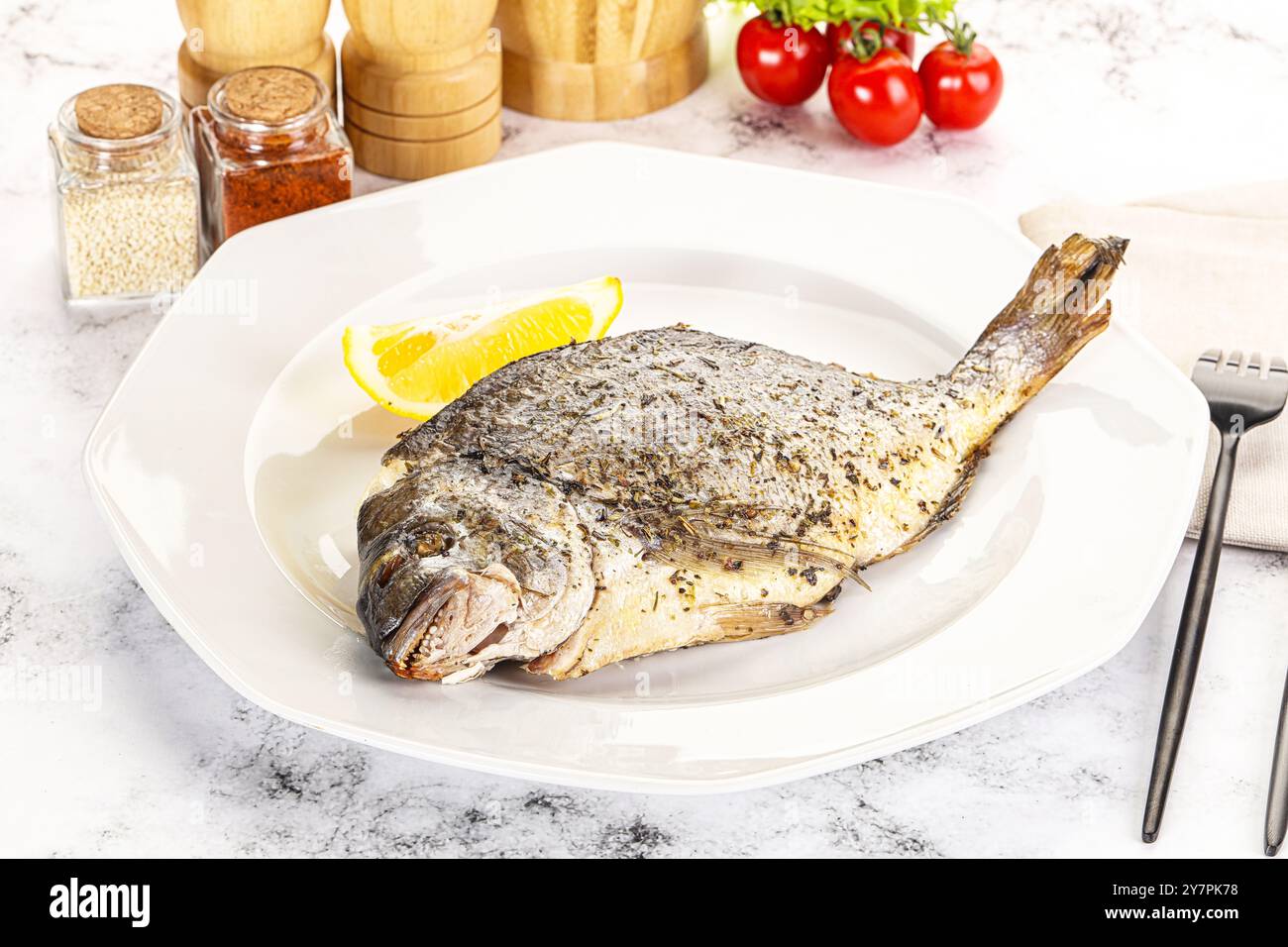 Baked Dorado fish served lemon slice Stock Photo - Alamy