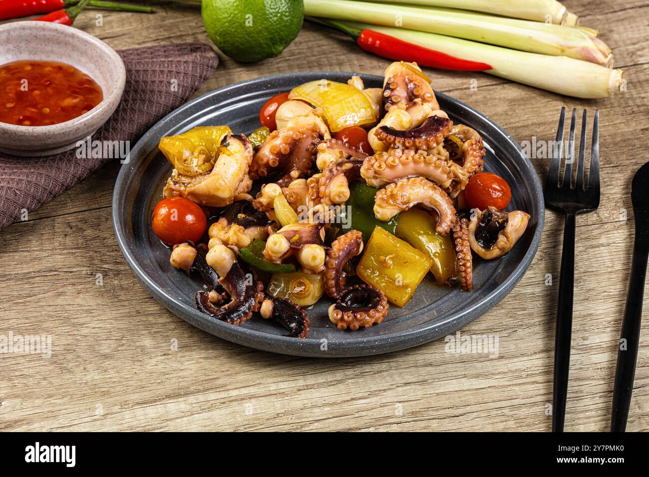 Roasted octopus with vegetables, spices and oil Stock Photo - Alamy