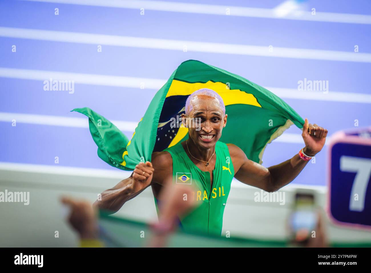 Alison dos Santos celebrating with her country's flag in the 400 meters ...