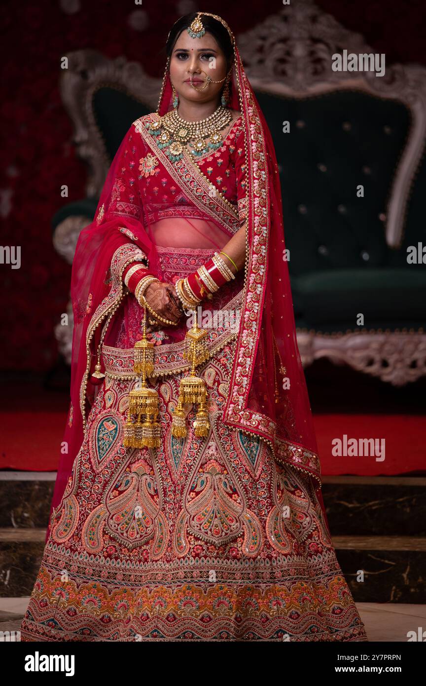 An Indian bride in traditional red bridal attire with intricate ...