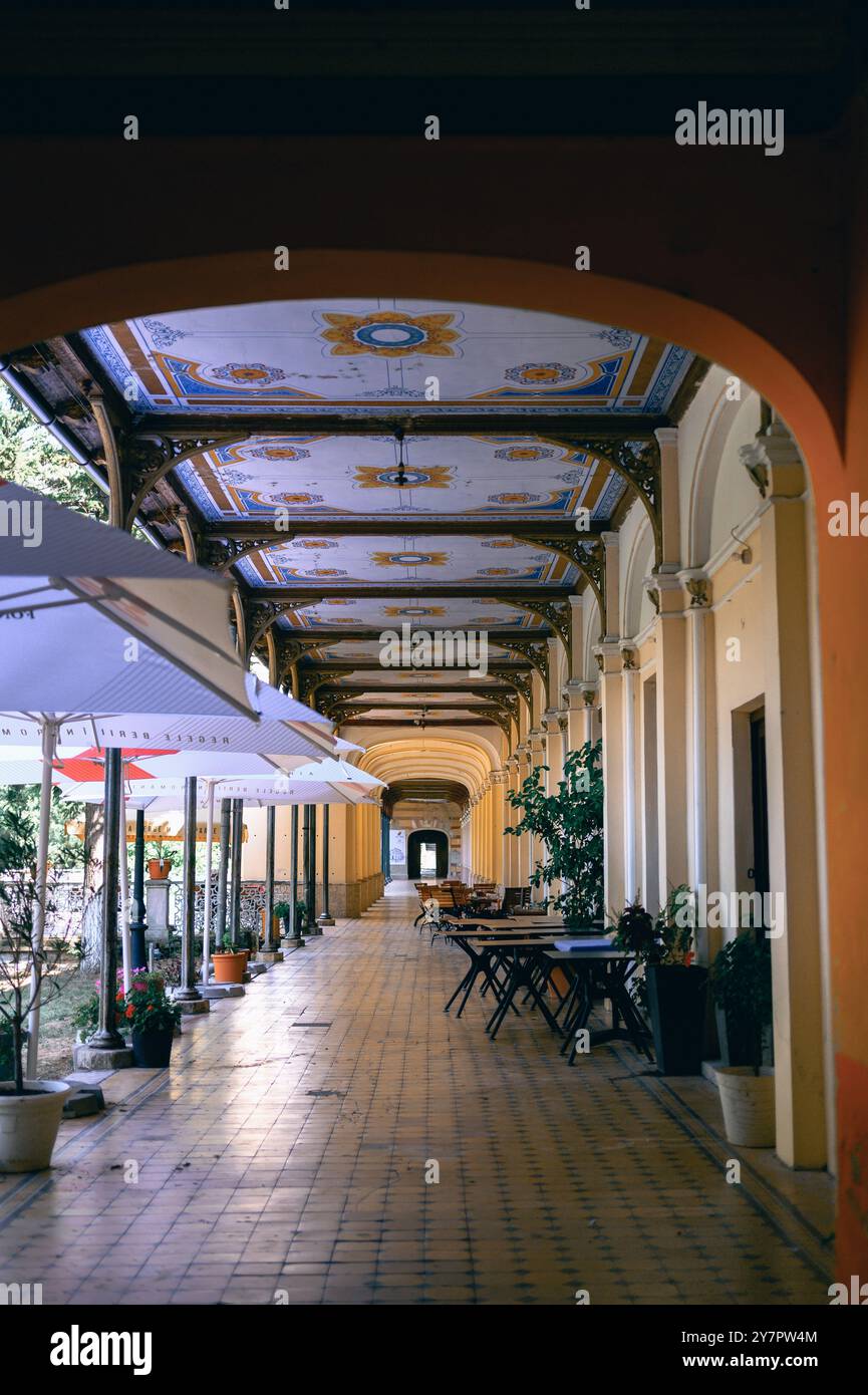 A beautiful outdoor corridor with decorated ceiling and tables set for ...