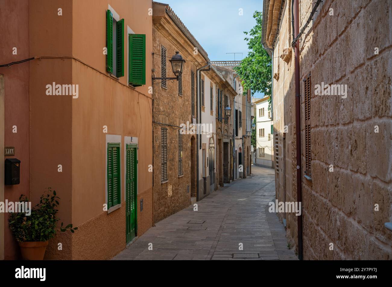 A picturesque narrow street in a Mediterranean village with colorful ...