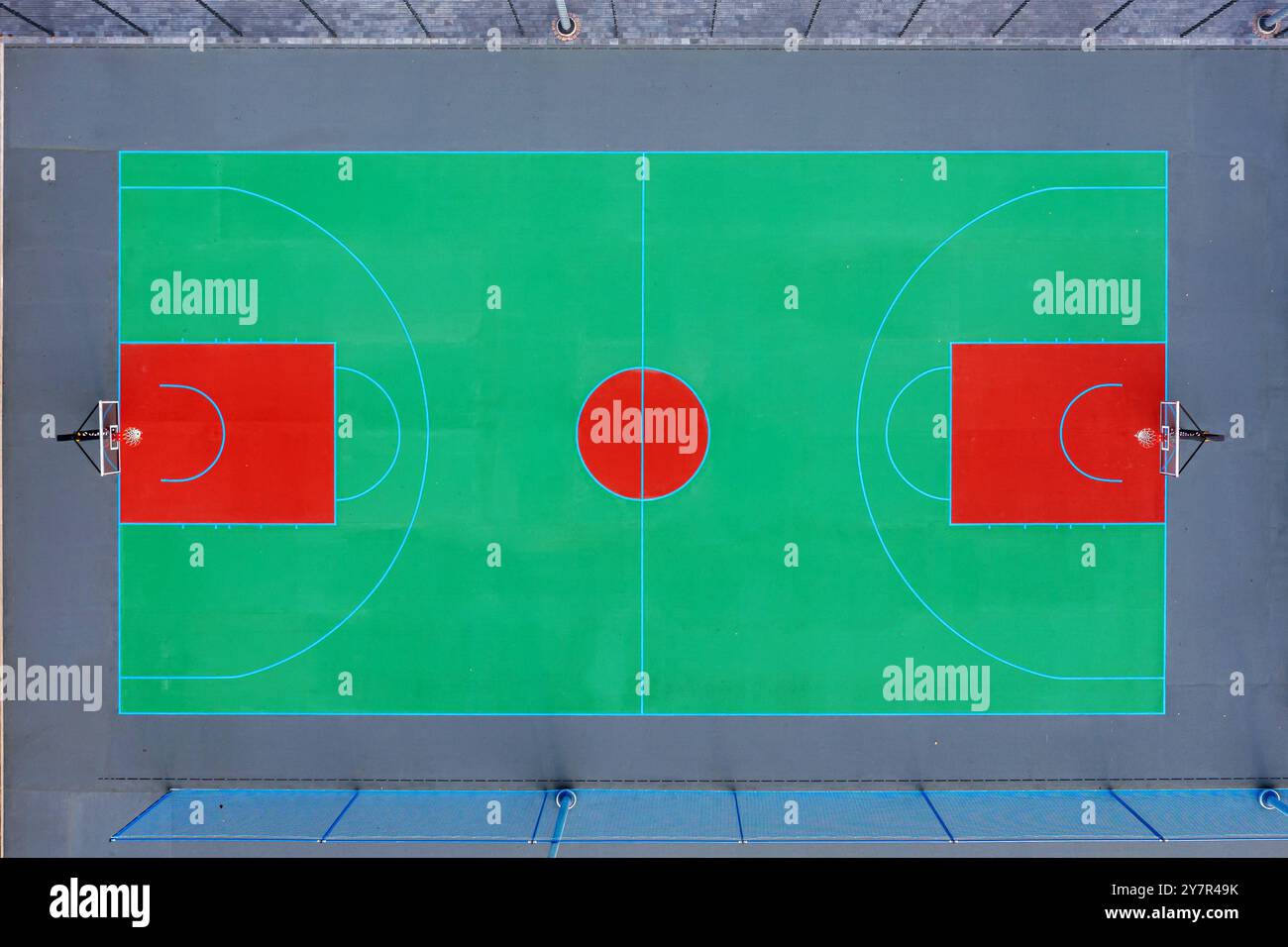 An overhead view shows a newly painted basketball court in bright red ...