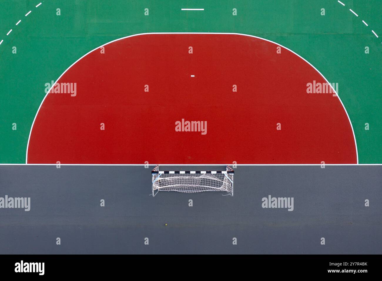 A brightly colored sports court features basketball markings and a goal ...