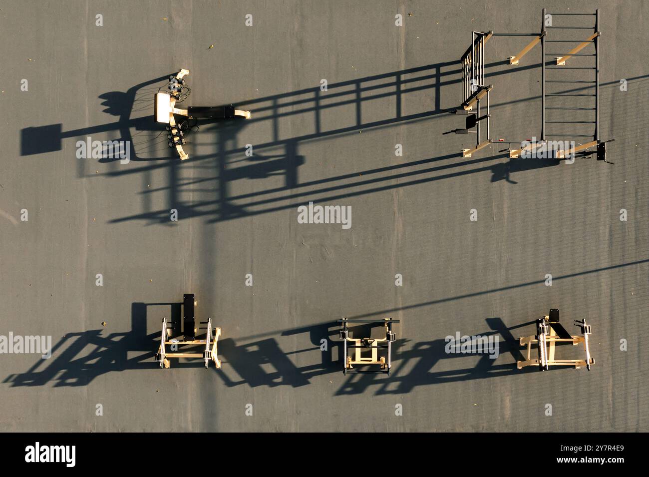 Equipment displays dramatic shadows on a flat area in the warm light of ...